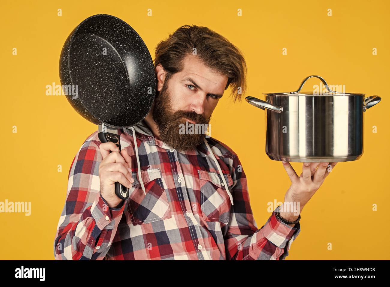 mature handsome man in checkered shirt hold pan for cooking food ...