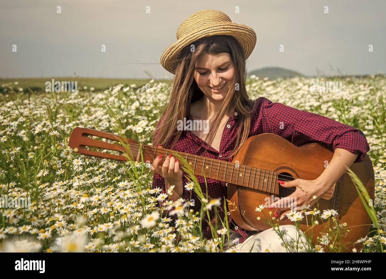 happy woman gather flowers in summer daisy field play acoustic guitar ...
