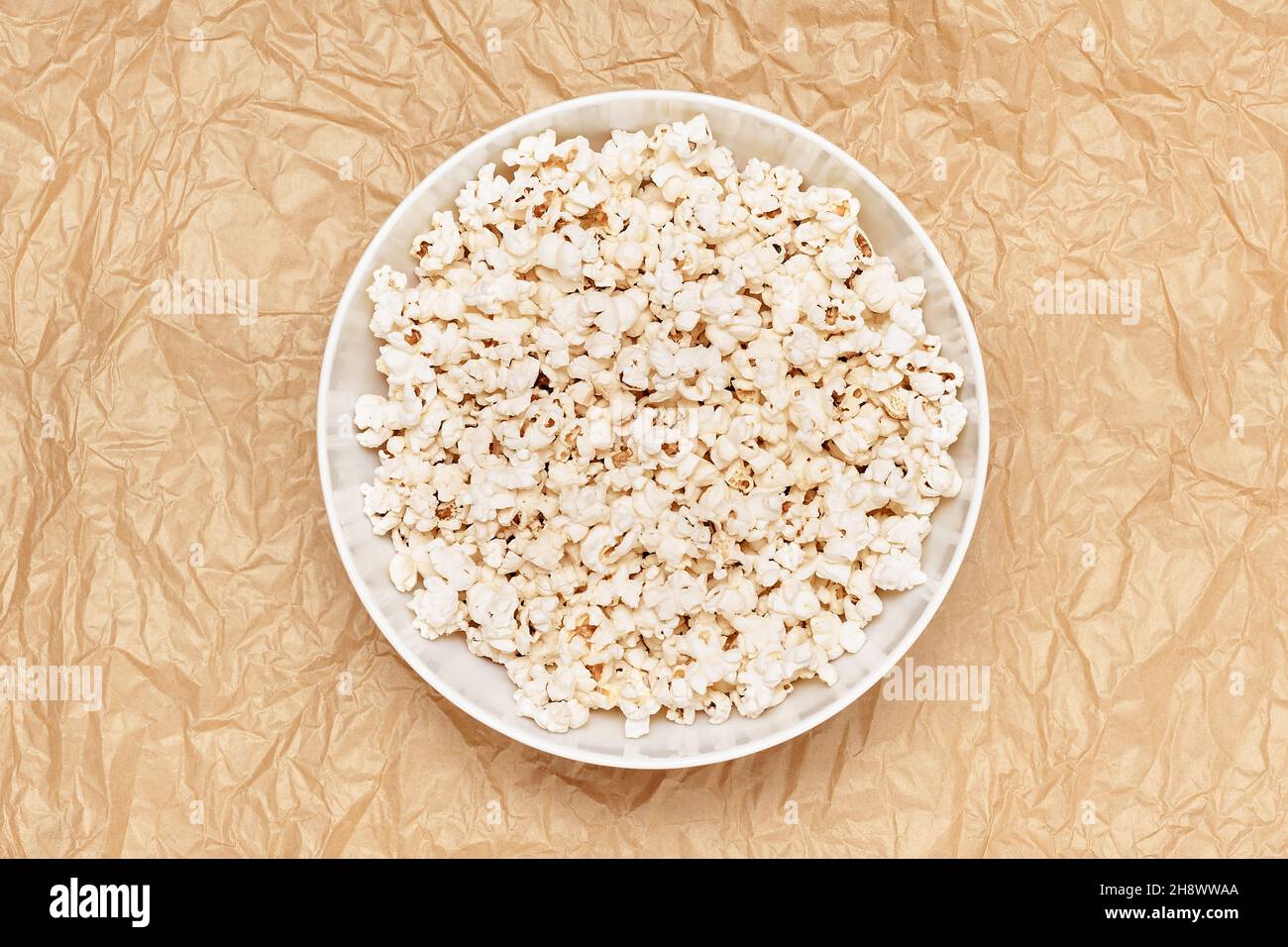 Popcorn in a bowl on craft paper Stock Photo - Alamy
