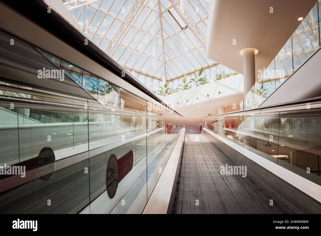 Flat escalator in a shopping mall without people, luminous unfocused ...