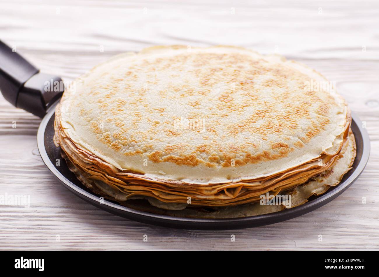 Stack of French crepes in frying pan on wooden kitchen table Stock ...