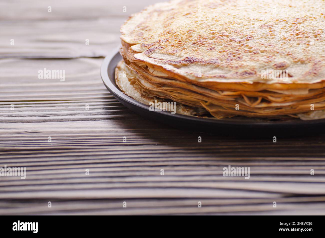 Stack of French crepes in frying pan on wooden kitchen table Stock ...
