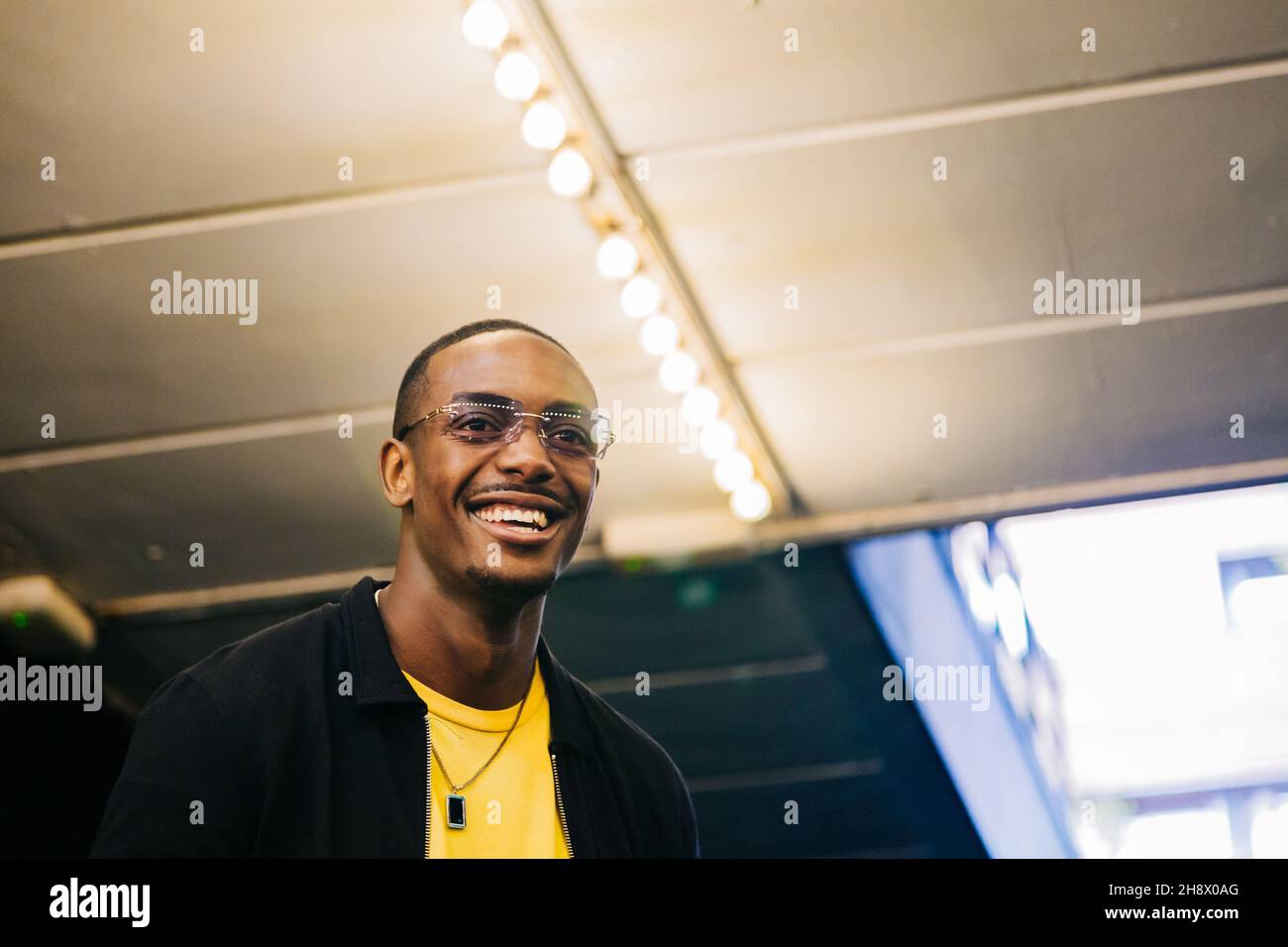 Low angle of delightful African American male wearing eyeglasses in ...