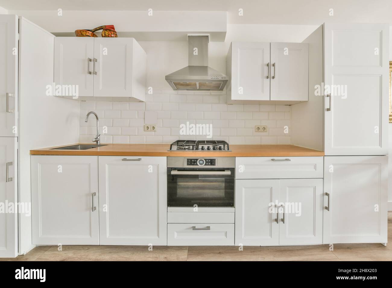 Counter with gas cooker and oven with white cabinets in light spacious ...