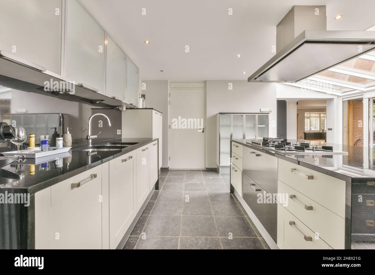 Counter with cooker against white cabinet with sink and various ...