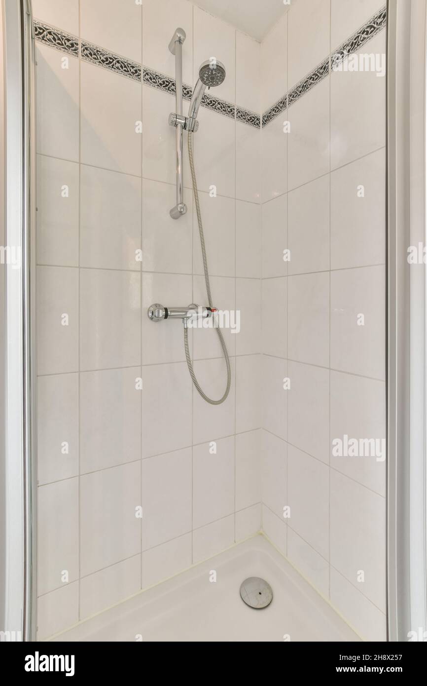 Interior of bathroom with empty shower cabin with light tiled walls in ...