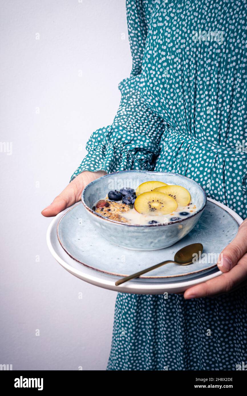 Crop anonymous female in dress carrying bowl of healthy granola mixed ...