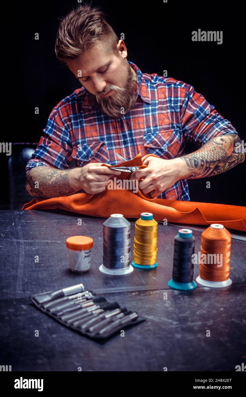 Worker of leather creates a new leatherwork at the tanning shop Stock ...