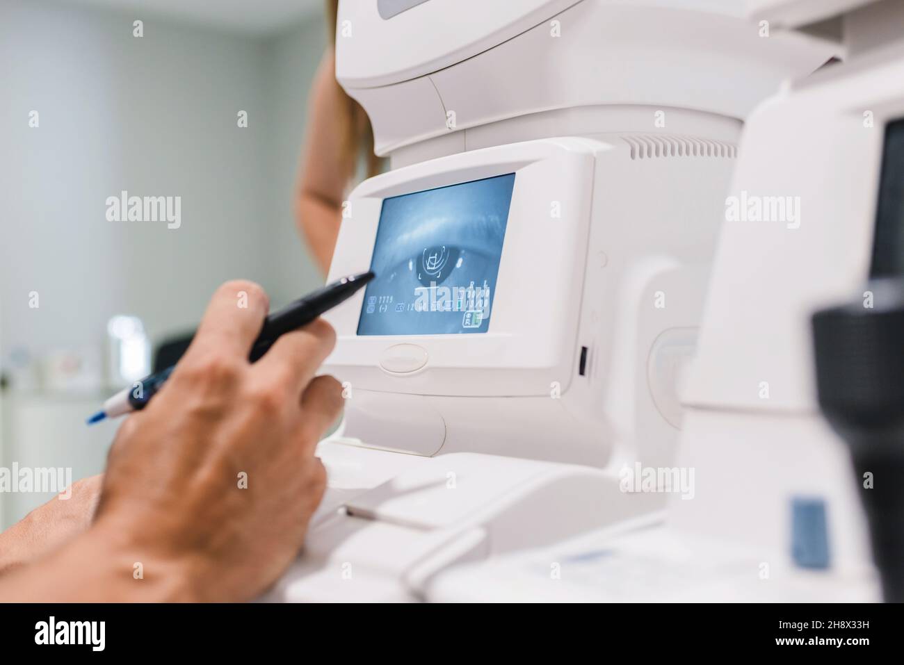 Crop anonymous male doctor ophthalmologist conducting autorefractometry ...