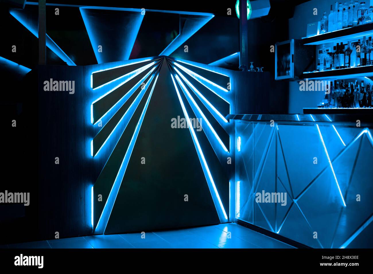 Interior of modern bar with creative blue neon illumination and shelves ...