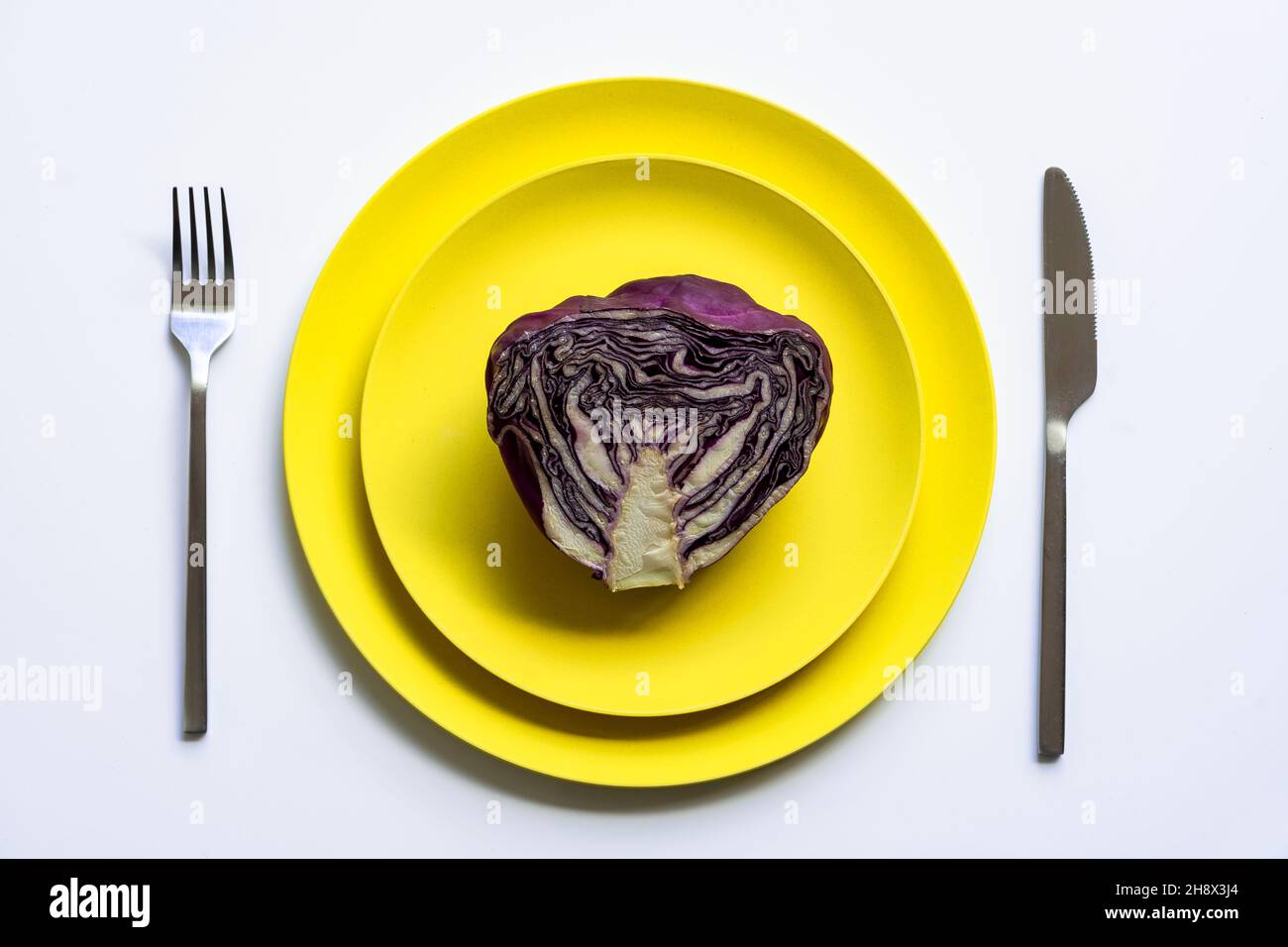 From above of halved red cabbage placed on yellow plates on white ...