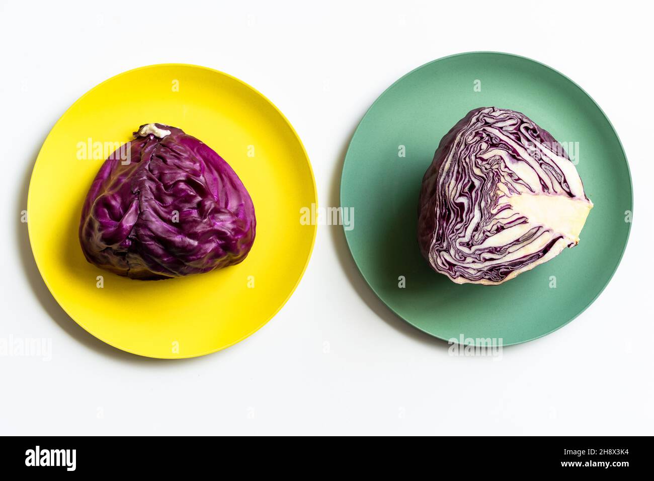 From above of halved red cabbage placed on yellow and green plates on ...
