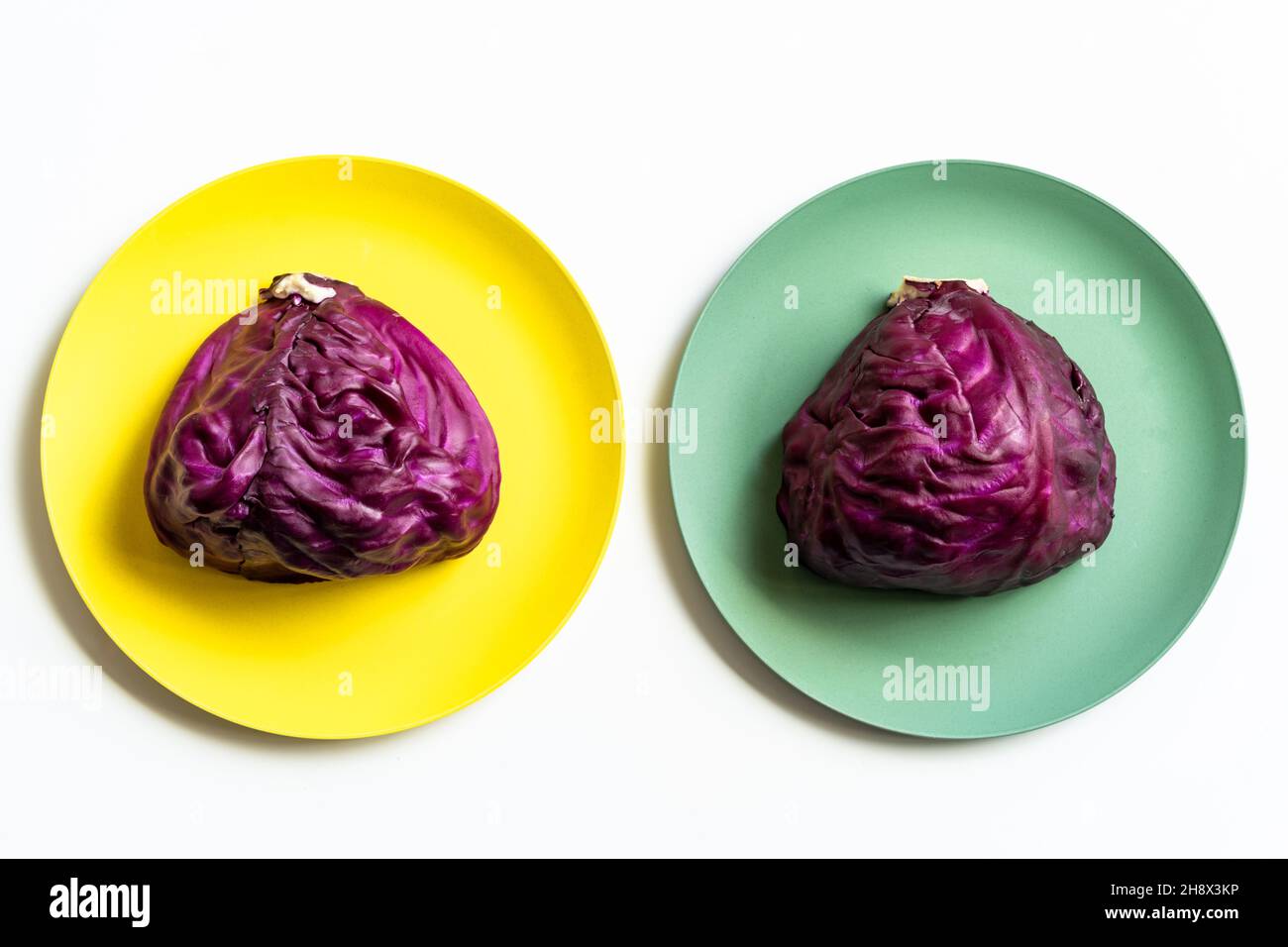 From above of halved red cabbage placed on yellow and green plates on ...
