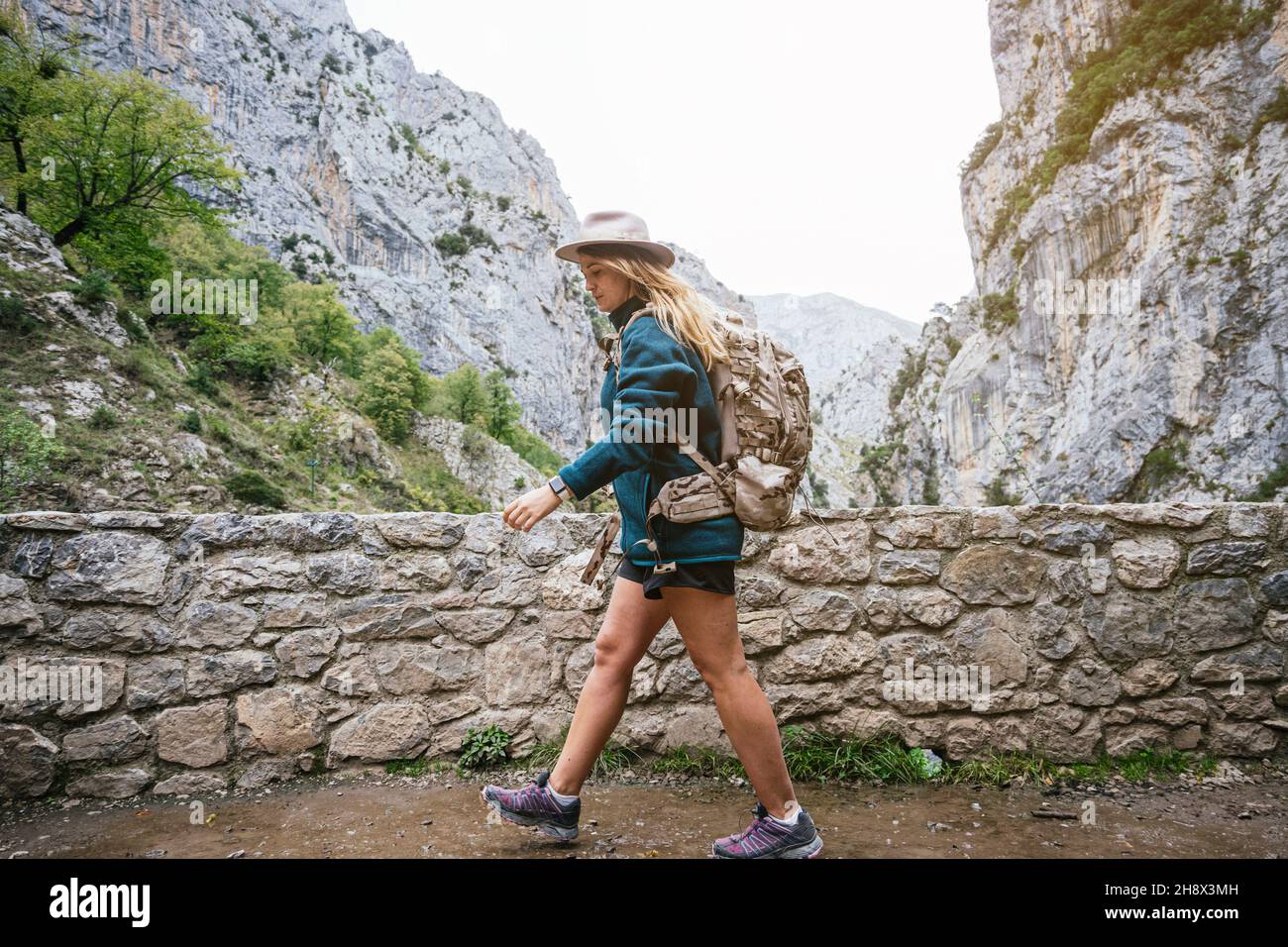 Side view full body of female backpacker strolling in pathway past ...