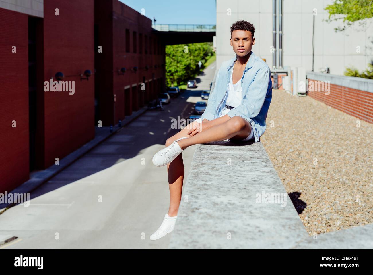 Young man sitting on rooftop hi-res stock photography and images - Alamy