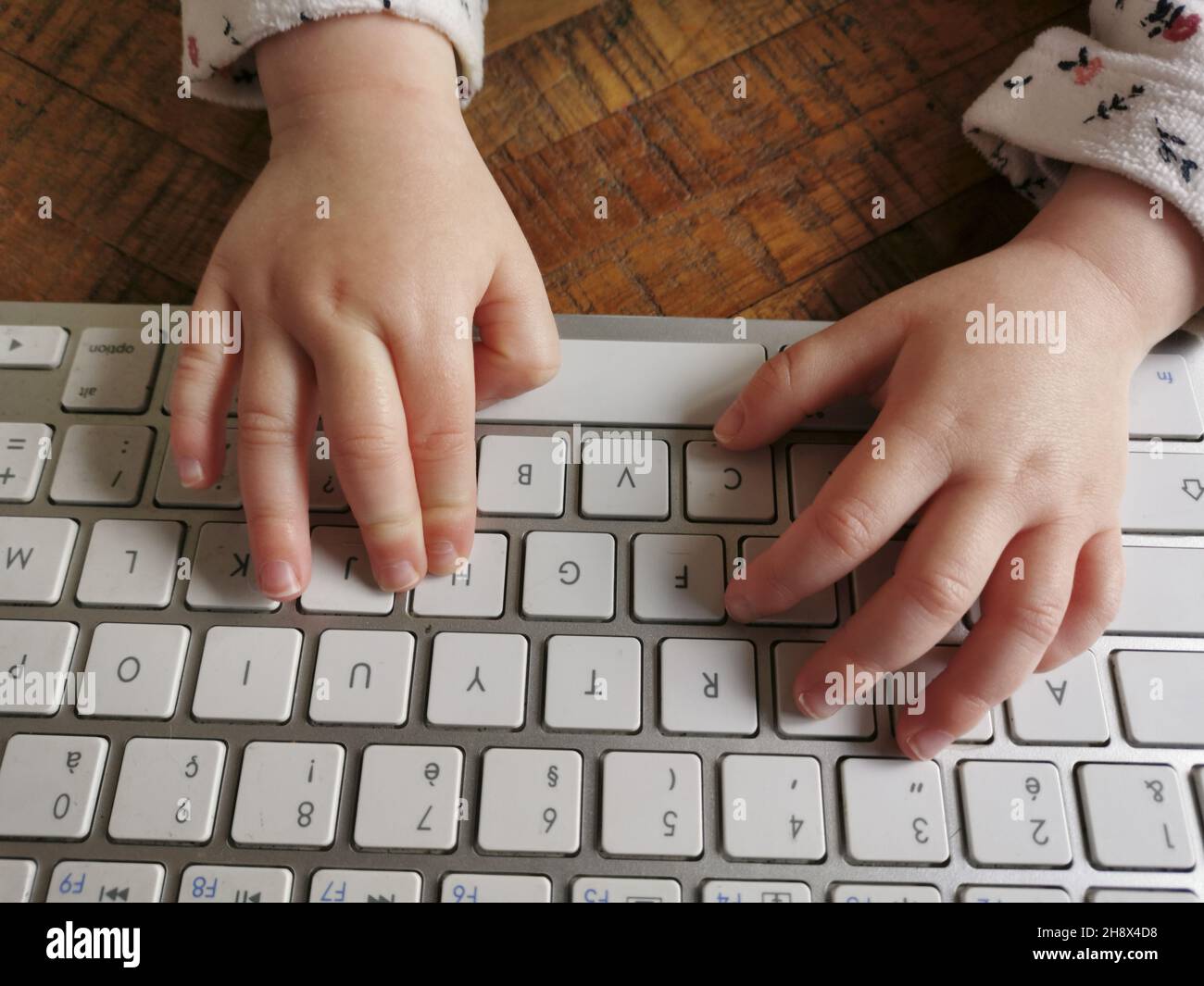 Kid's hands on a computer keyboard Stock Photo - Alamy