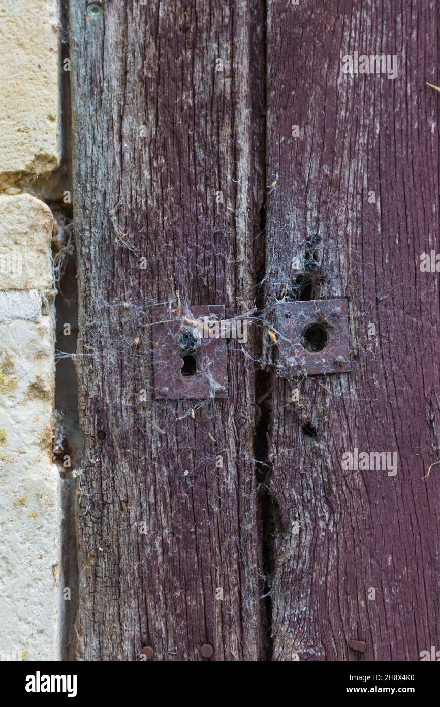 Iron lock on an old wooden door on an abandoned out-building at a ...
