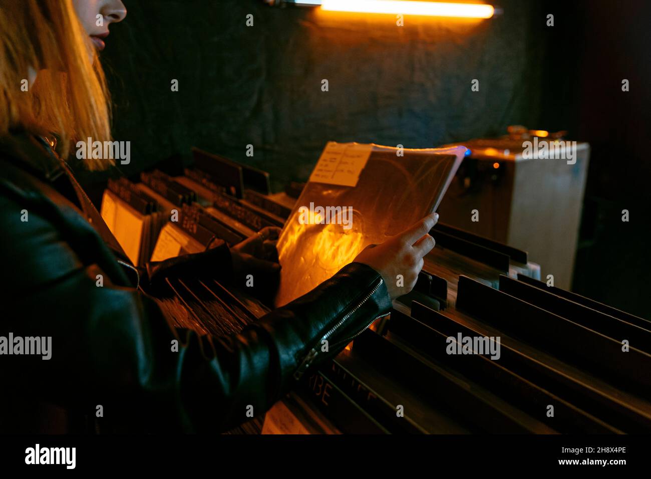 Anonymous young female choosing vinyl record while standing near ...