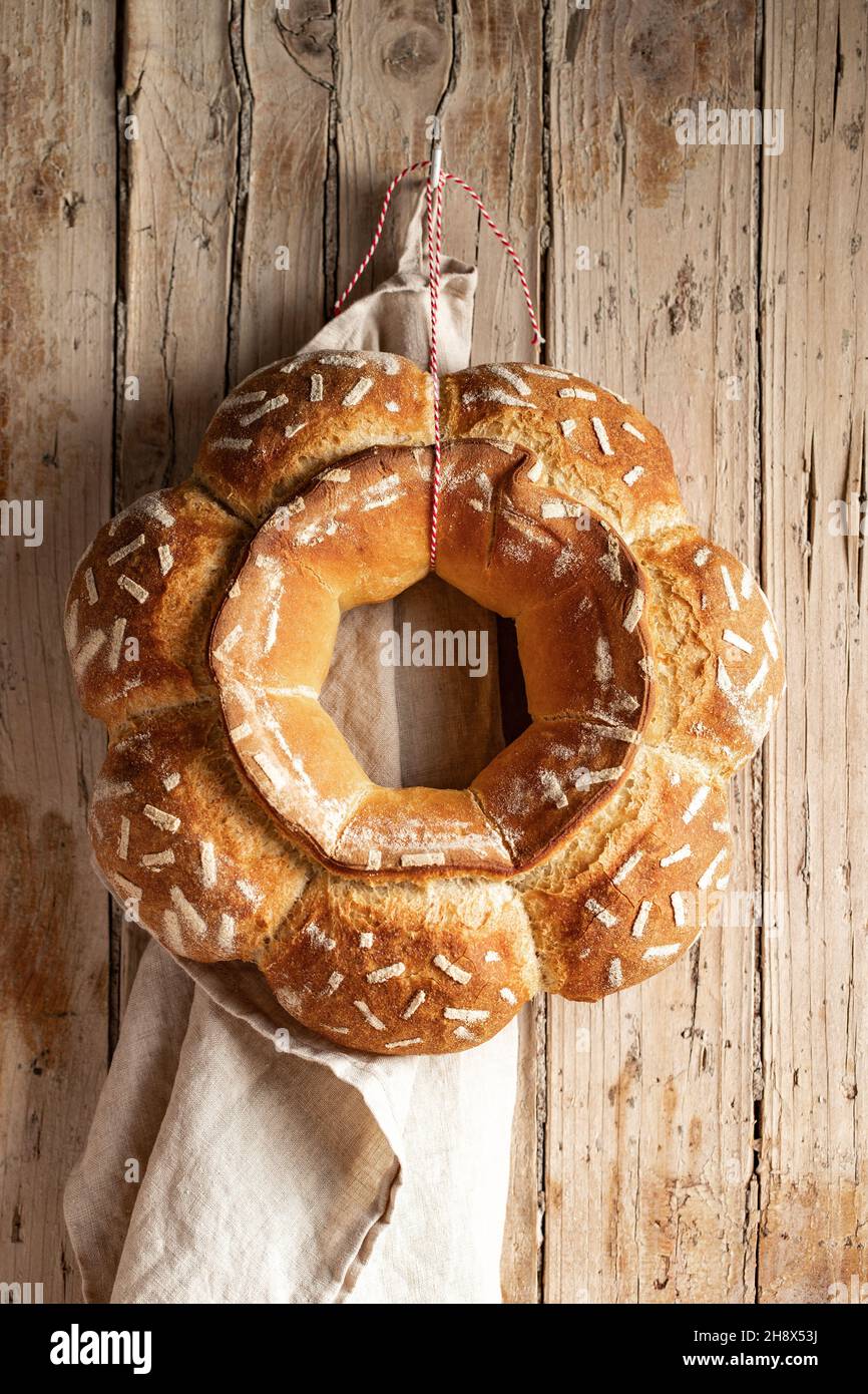 Decorative round baked loaf of bread with white patterns hanging on ...