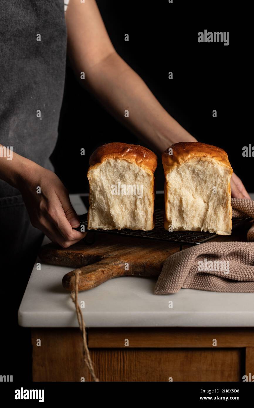 Unrecognizable crop baker taking split halves of sandwich bread from ...