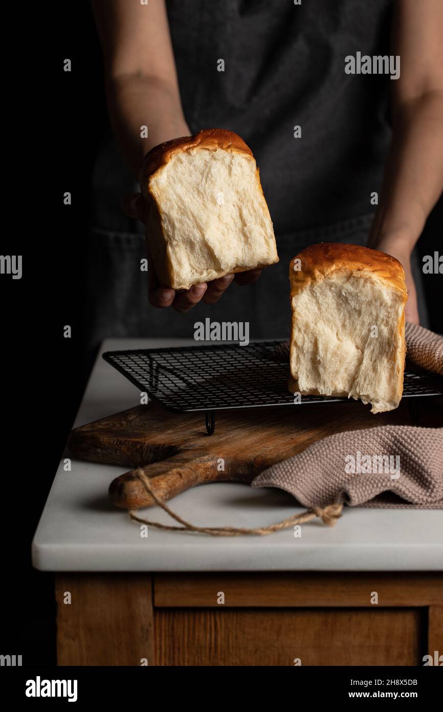 Unrecognizable crop baker taking split halves of sandwich bread from ...