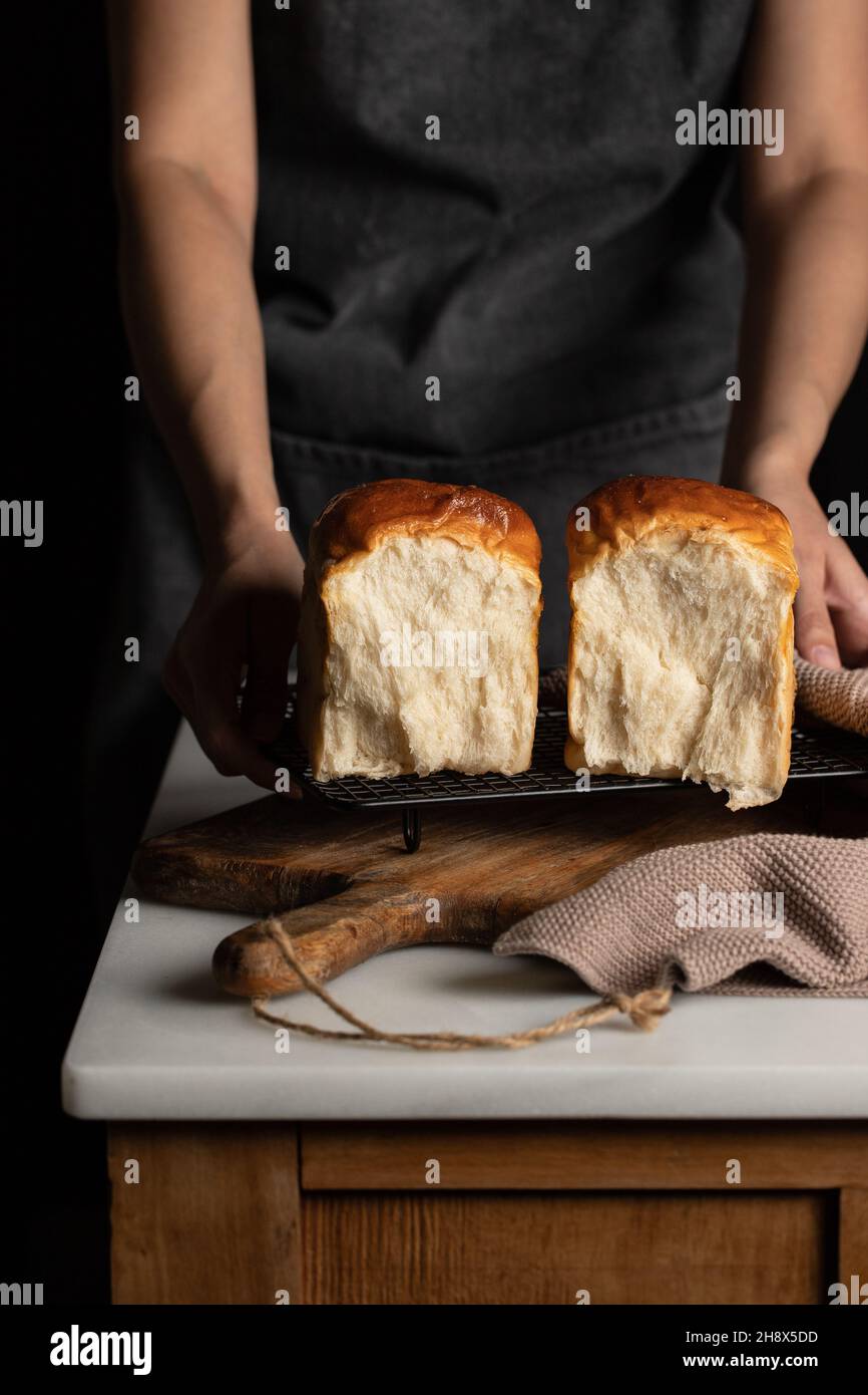 Unrecognizable crop baker taking split halves of sandwich bread from ...