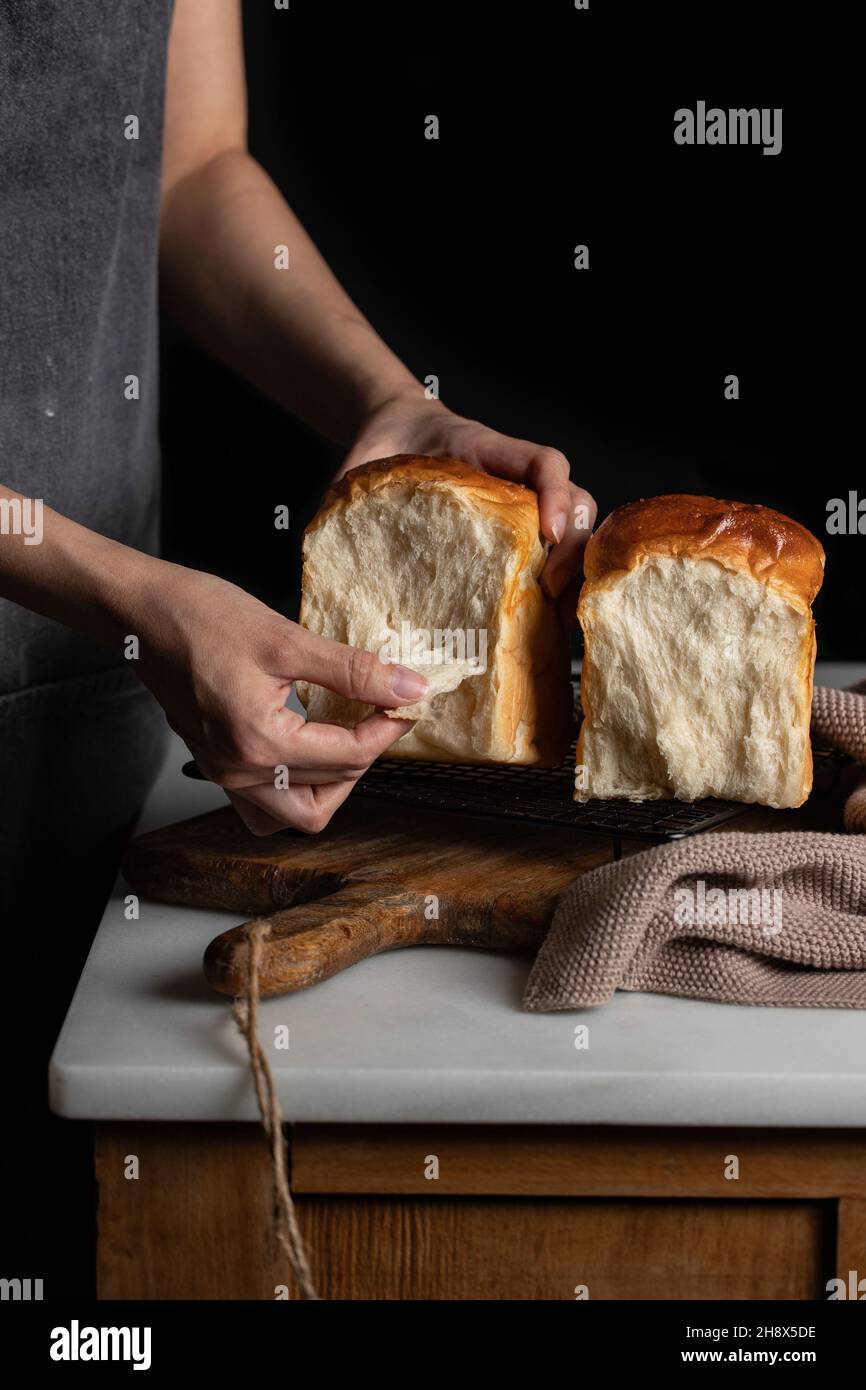 Unrecognizable crop baker taking split halves of sandwich bread from ...