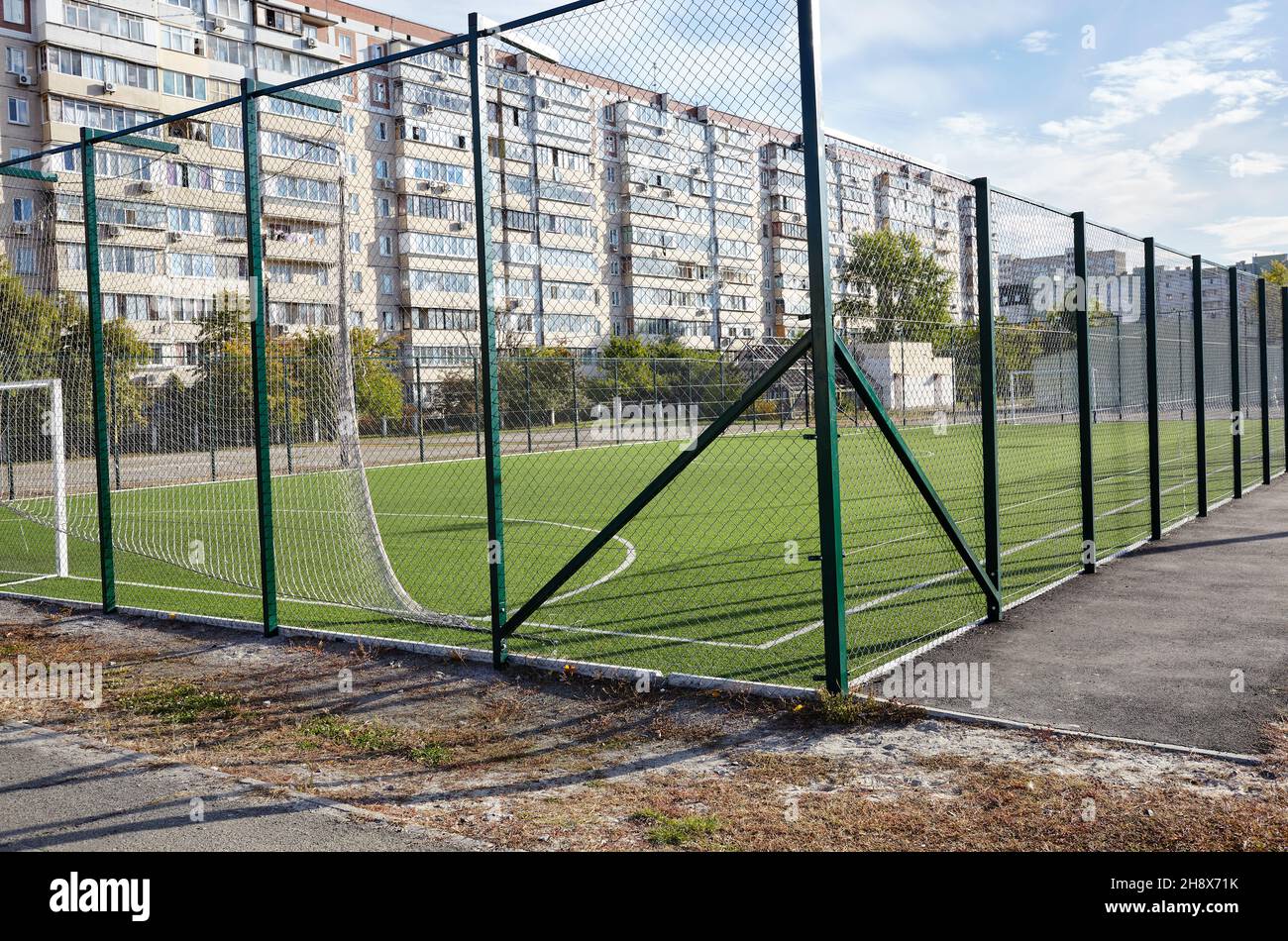 Lawn field for playing football behind the green fence mesh. Close-up ...