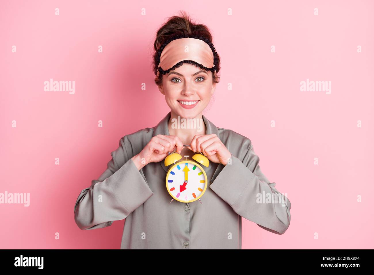 Portrait of attractive cheerful girl wearing pajama holding in hands ...