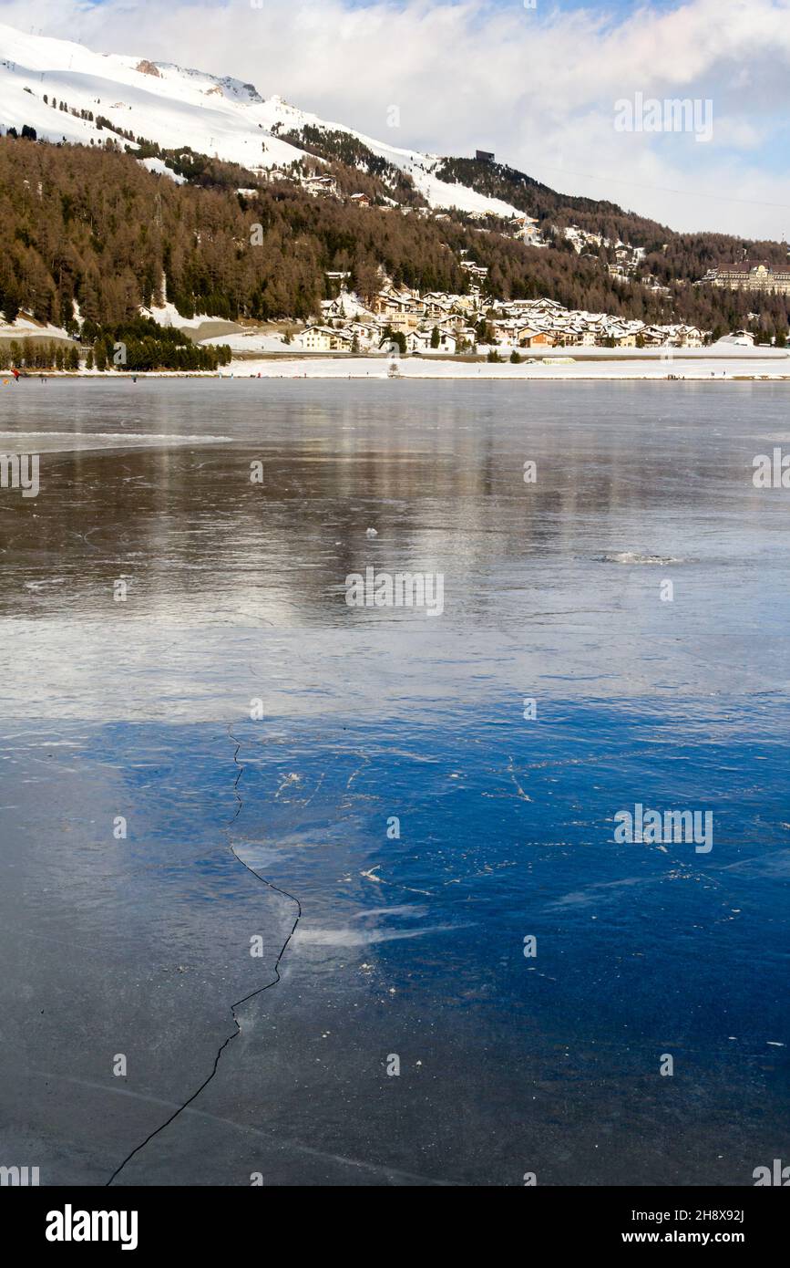 Frozen lake with ice crack on surface with city at the background ...