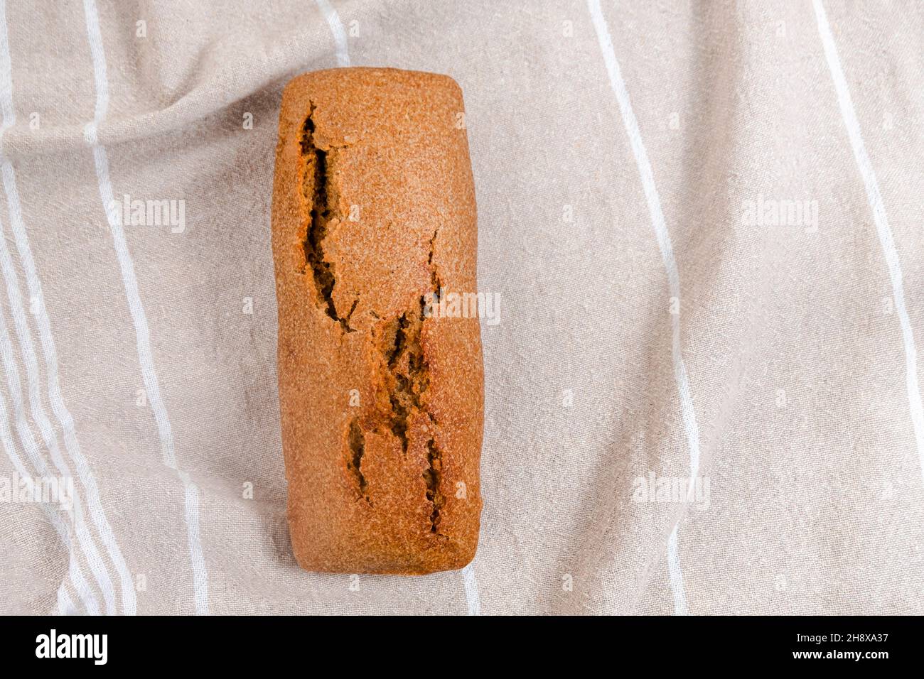 Homemade sourdough rye bread sliced on a cutting board on white table ...