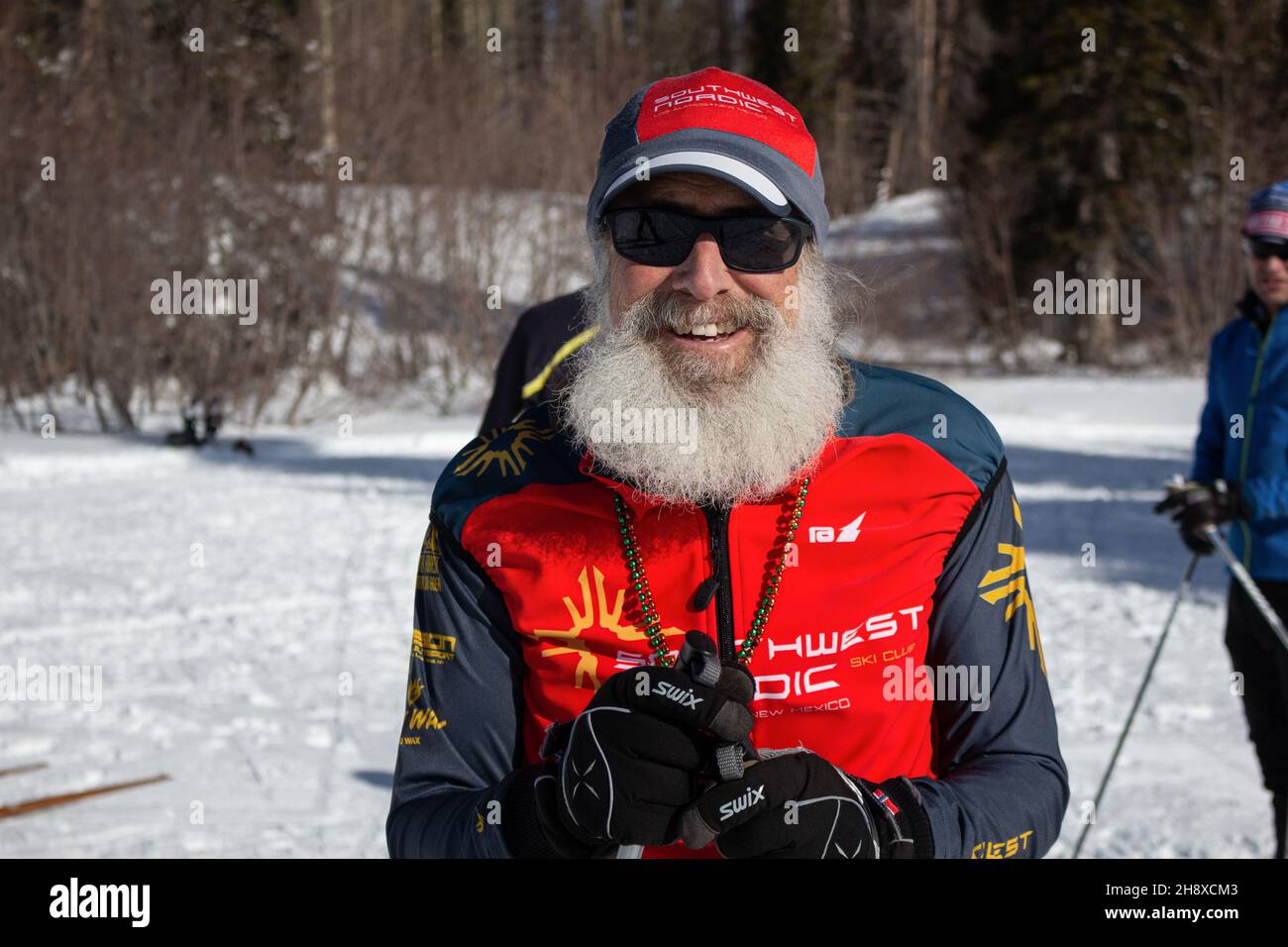 Elderly male with long white beard wearing ski clothes smiles during ...
