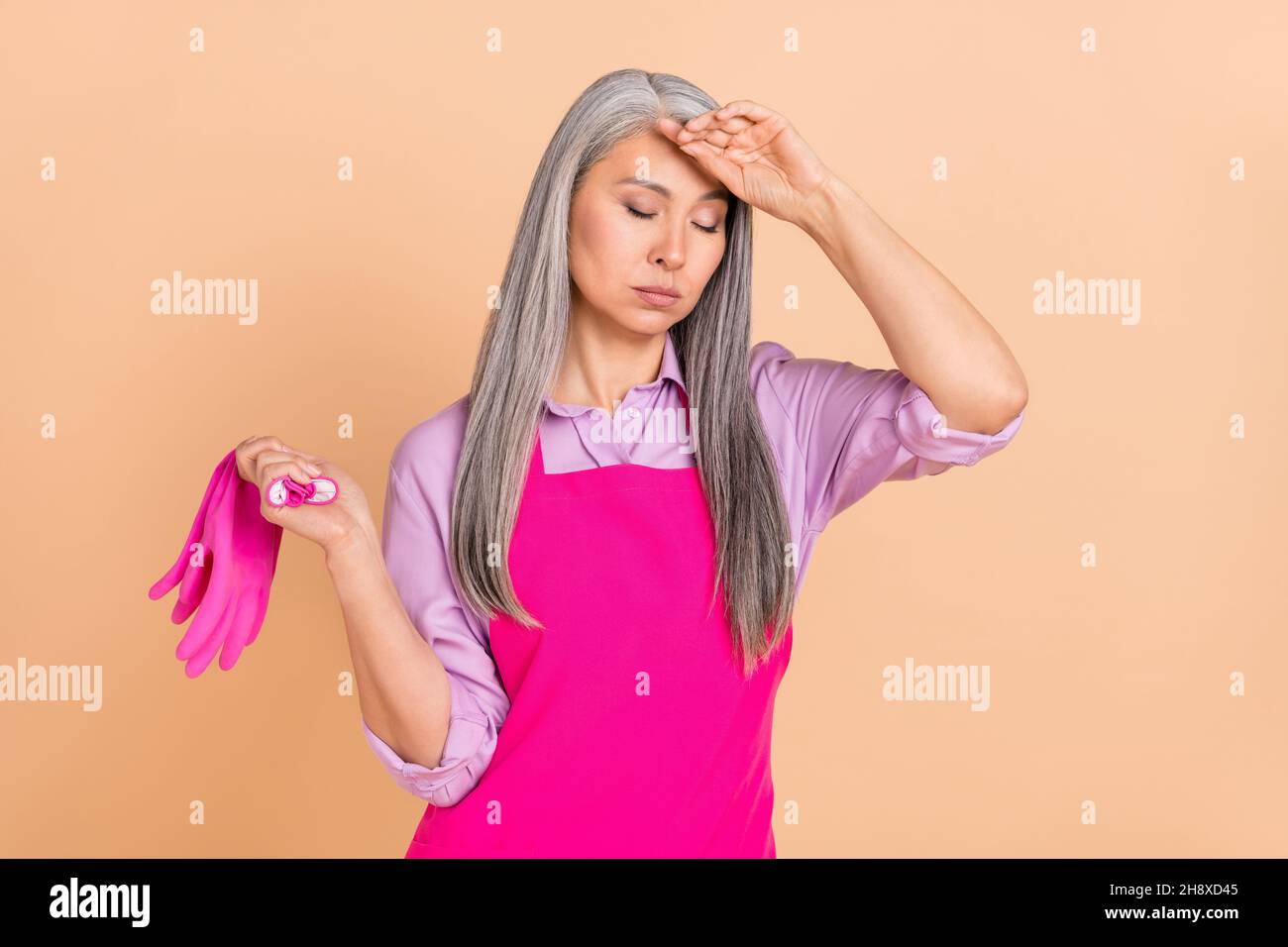 Portrait of attractive tired sad gray-haired woman doing clean up ...