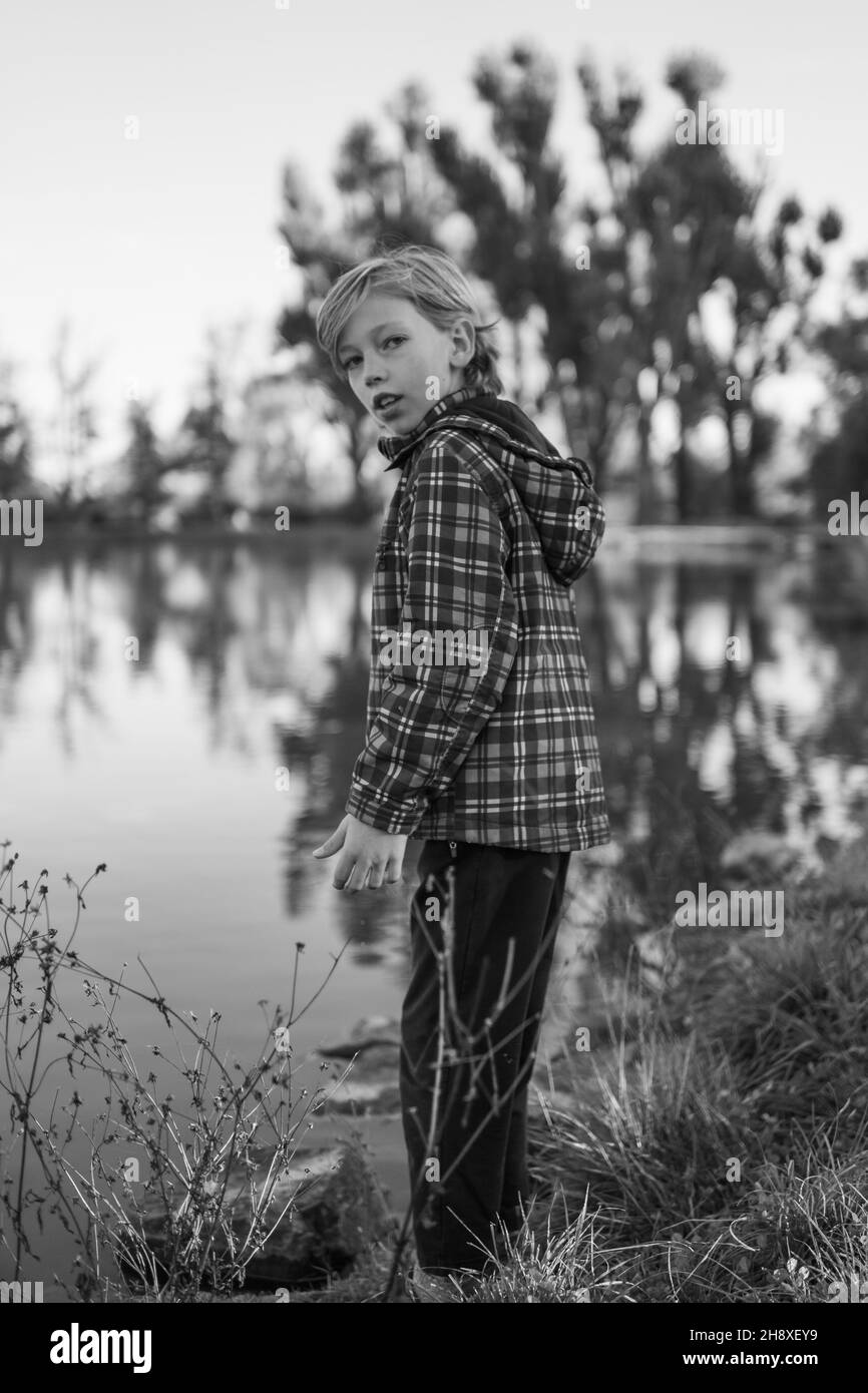 Grayscale shot of a kid on the riverside in spring Stock Photo - Alamy