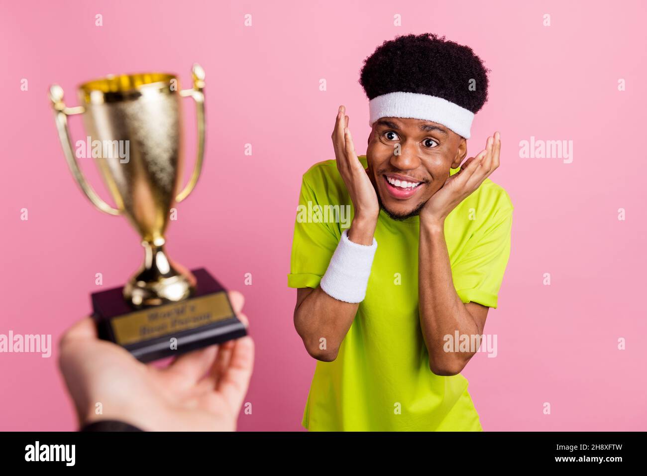 Portrait of attractive cheerful amazed guy sportsman receiving prize ...