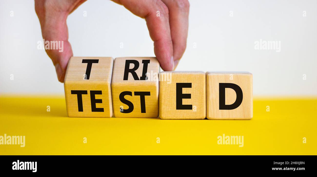 Tried and tested symbol. Businessman turns wooden cubes and changes the ...