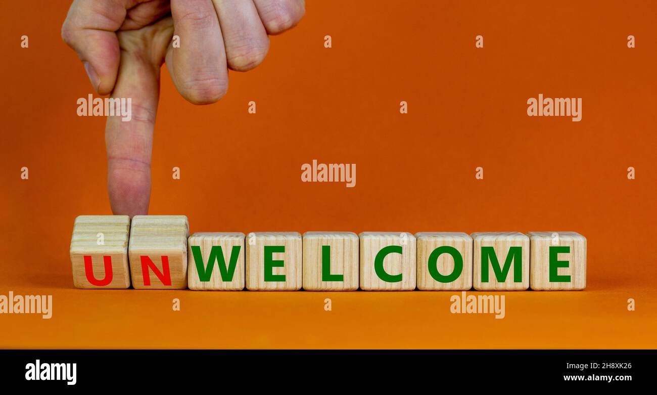 Welcome or unwelcome symbol. Businessman turns wooden cubes and changes ...