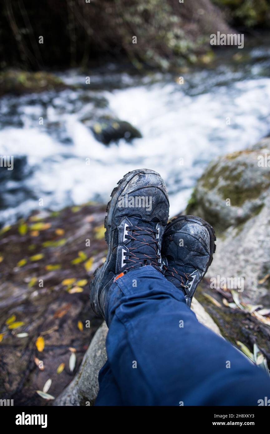 Detail of the boots of a man hiking along the bank of a river Stock ...