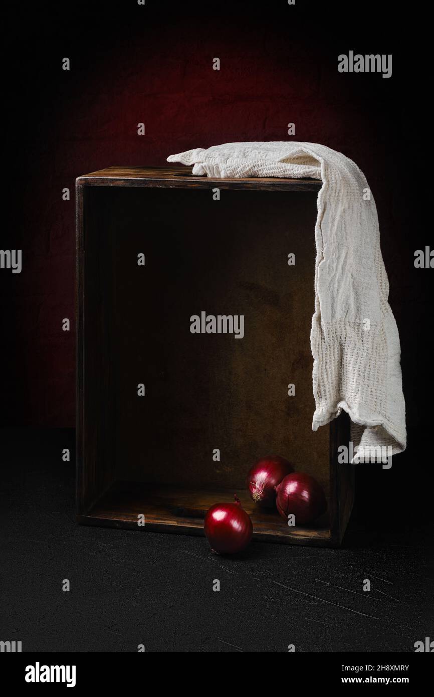 Low key photo of empty wooden box and three onions Stock Photo - Alamy