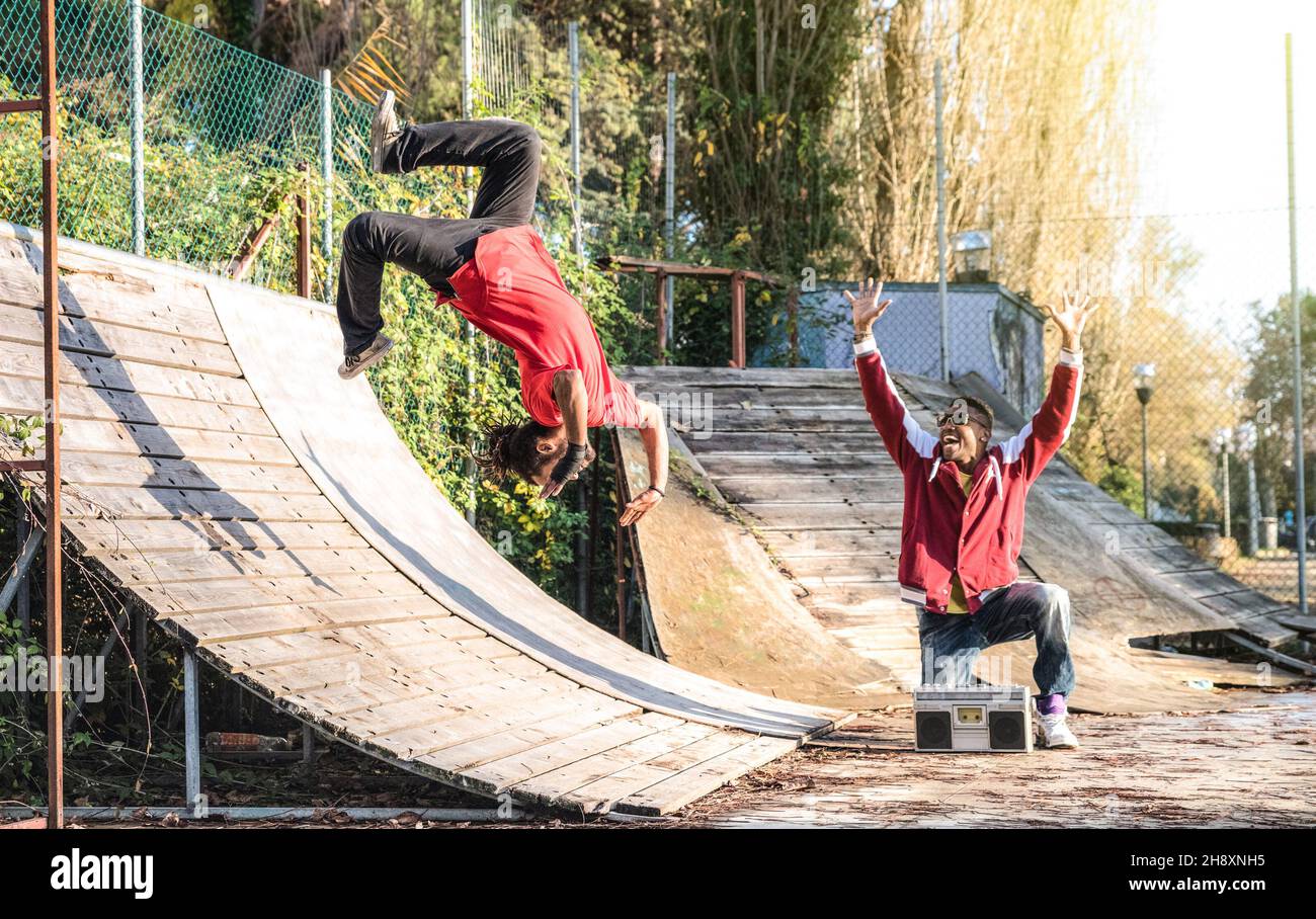 Urban athlete breakdancer performing somersault jump flip at skate park ...