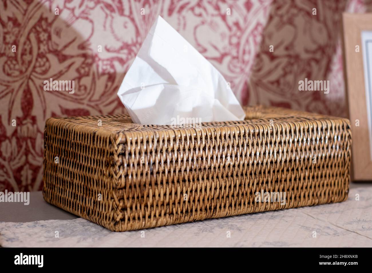 A handkerchief box made out of a weaved grass, sitting in a room on a ...