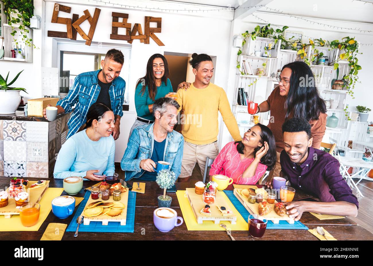 Friends having fun at breakfast buffet - Trendy multicultural people ...