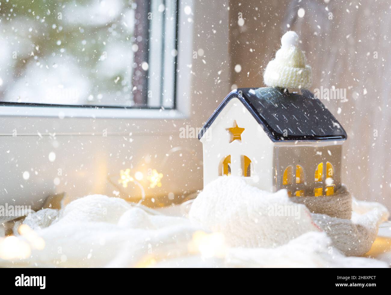 Cozy house is wrapped in a hat and scarf in a snowstorm -window sill ...