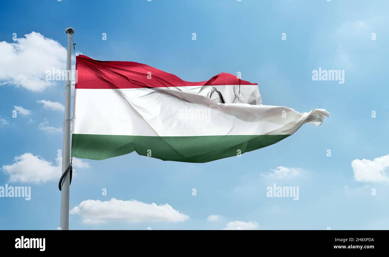 Hungarian flag waving on a pole in a blue sky Stock Photo - Alamy