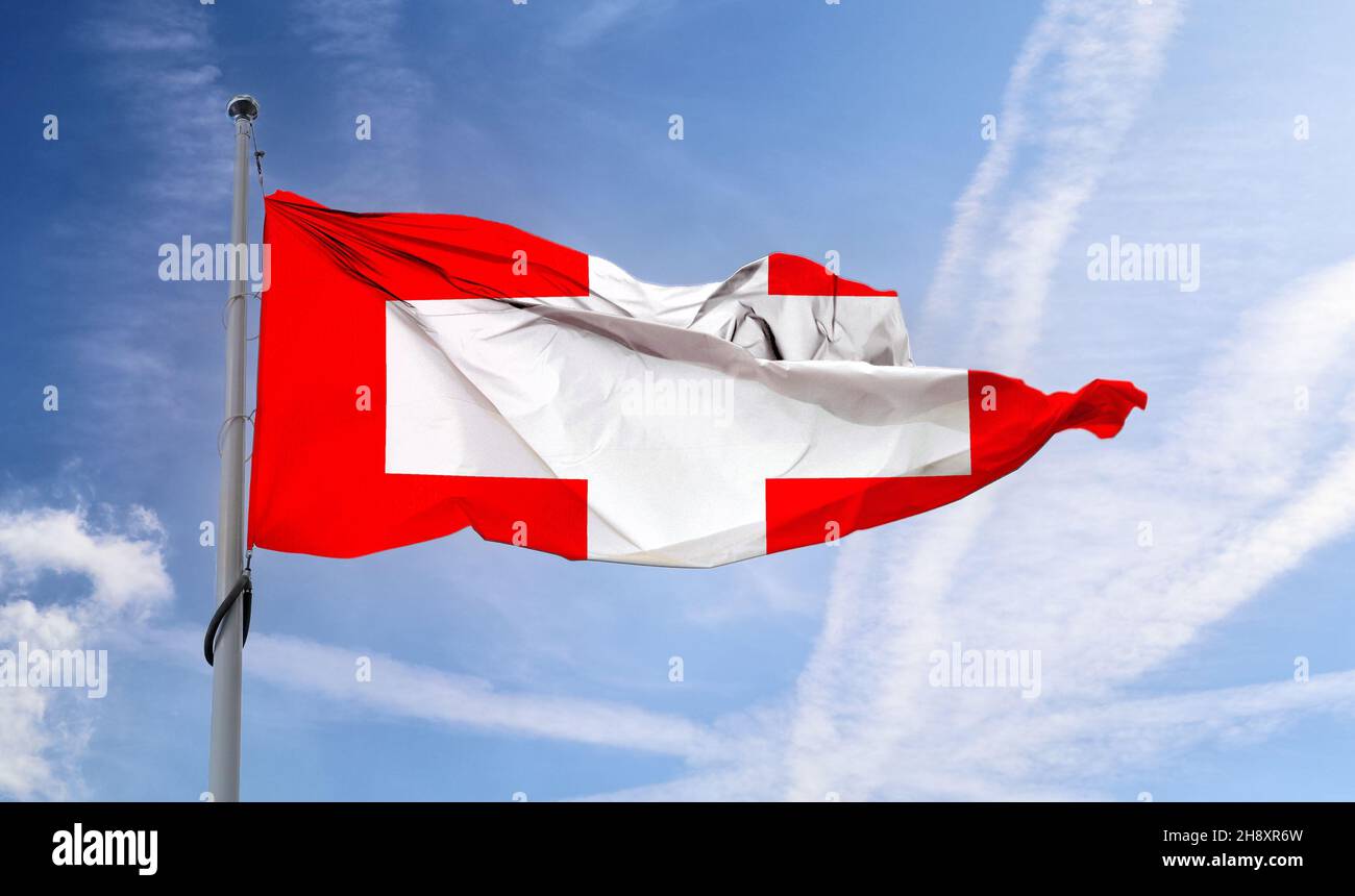 Swiss flag waving on a pole in a blue sky Stock Photo - Alamy