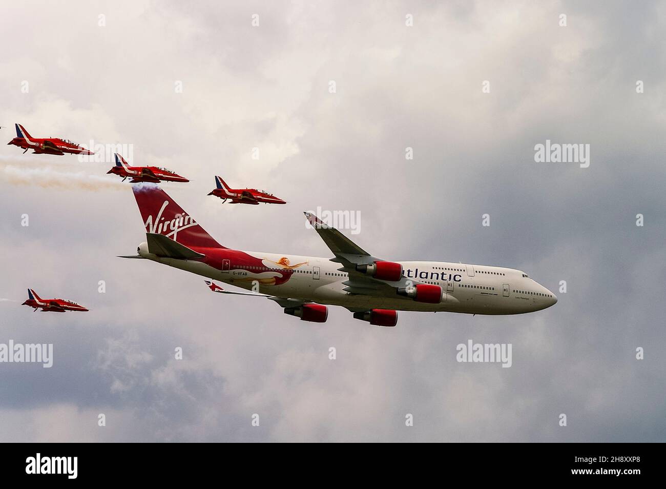 RAF Red Arrows jets flying alongside Virgin Atlantic airliner plane ...