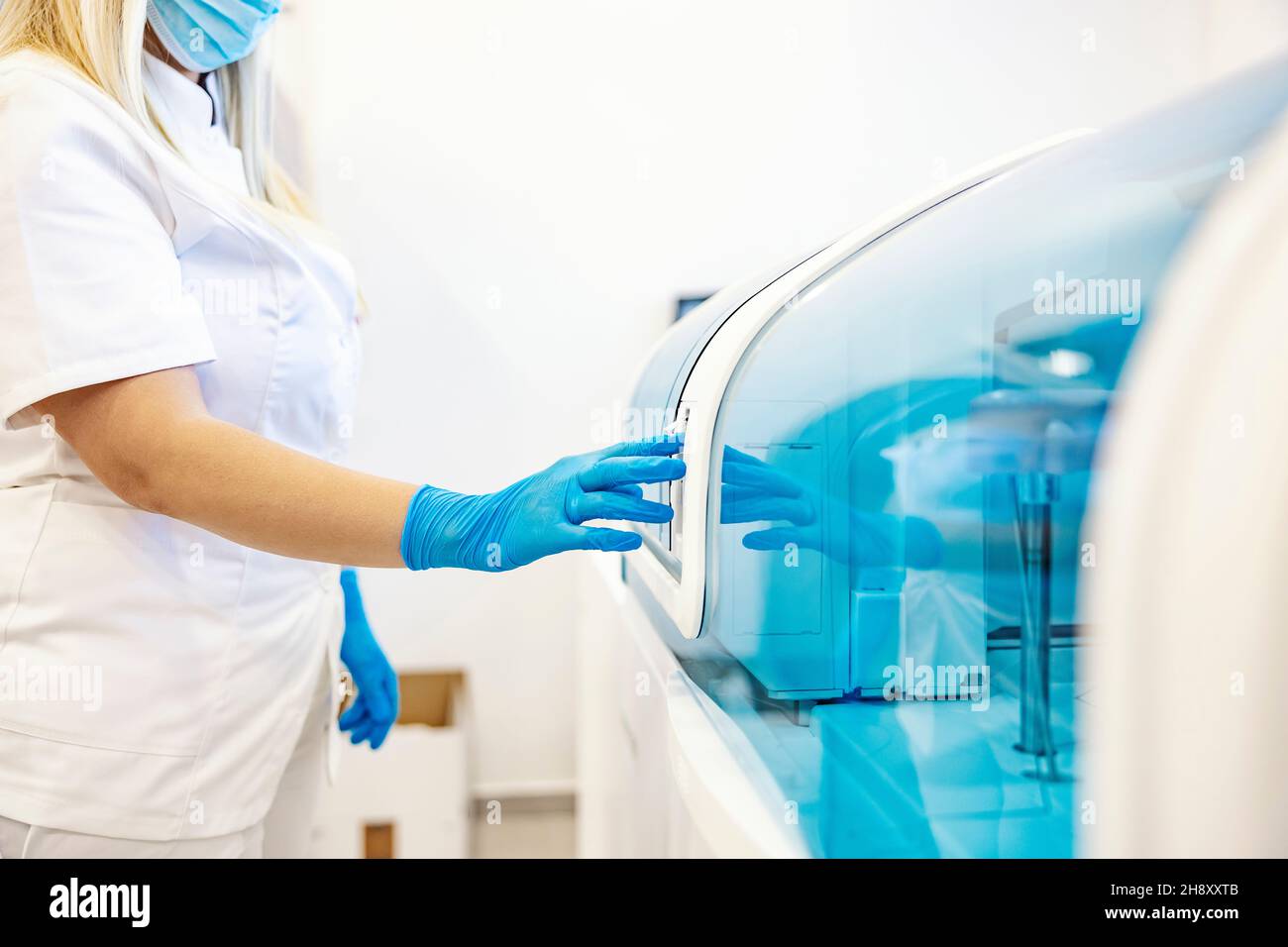 Machine for sampling in a lab. A nurse standing next to a blood ...