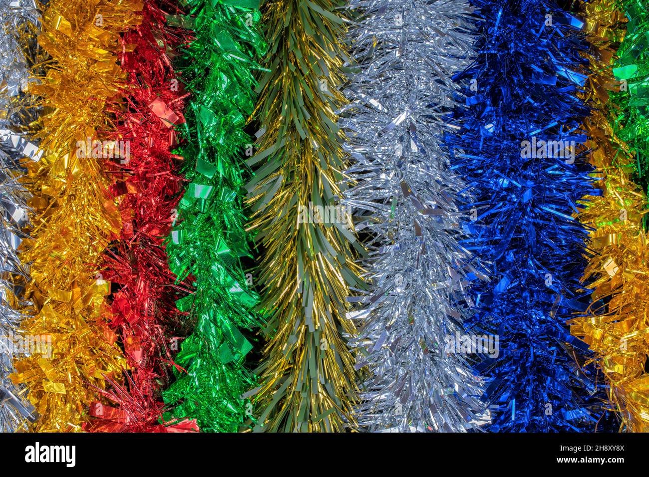 A Multi colored christmas tinsel background or texture Stock Photo - Alamy