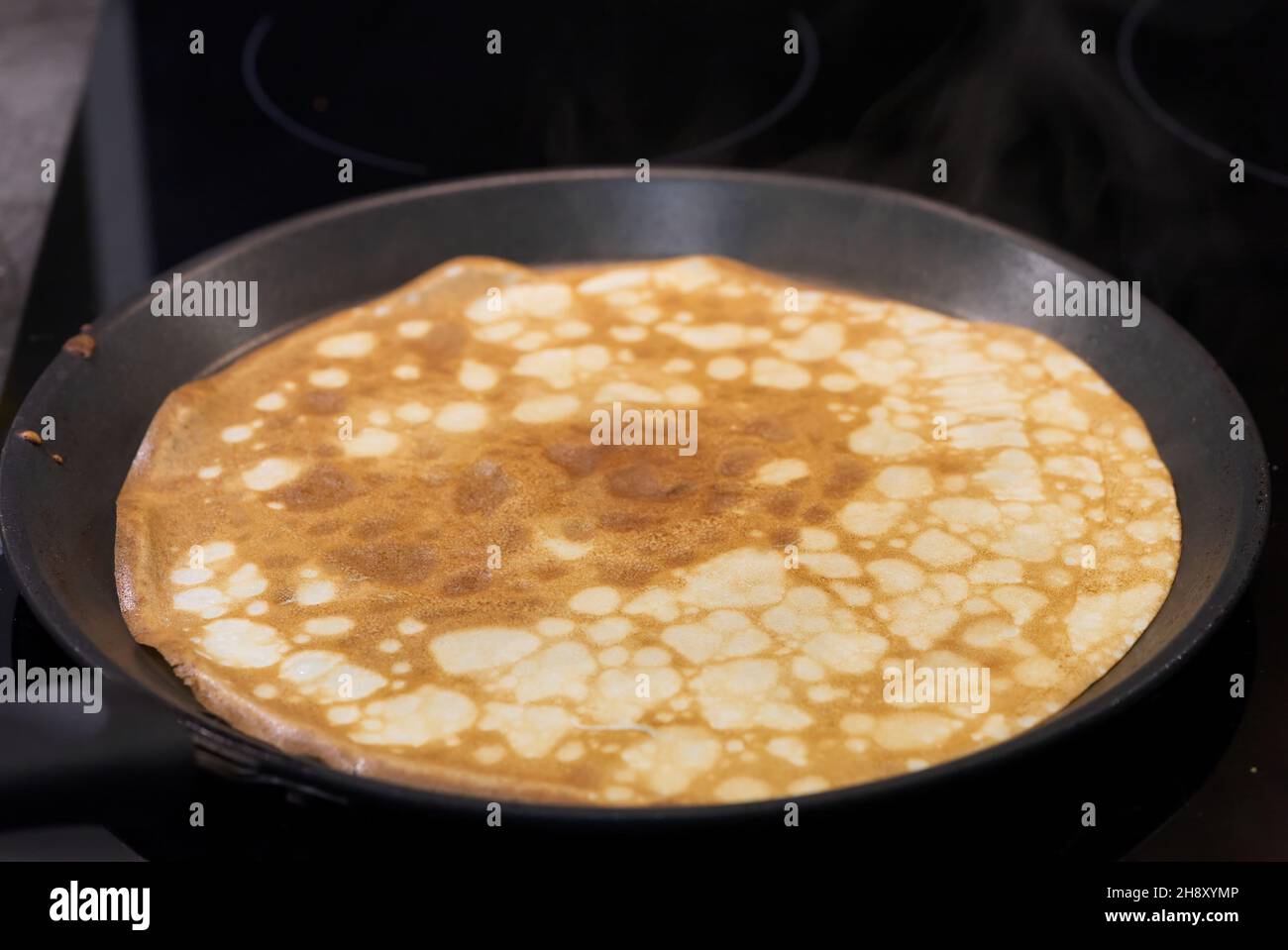 Pancakes in a frying pan. Cook preparing homemade pancakes Stock Photo ...