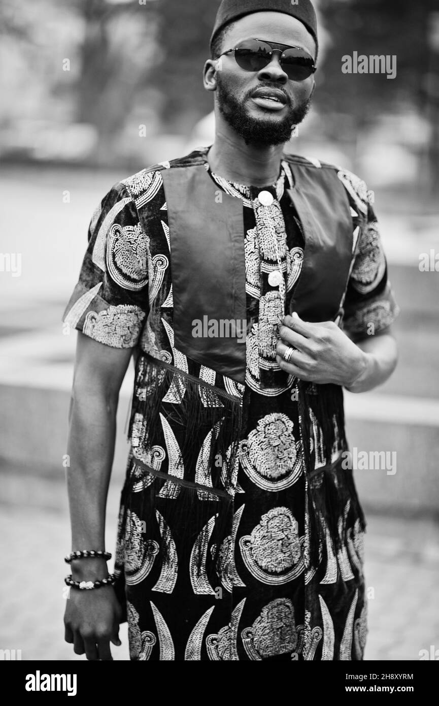 African stylish and handsome man in traditional outfit and black cap ...